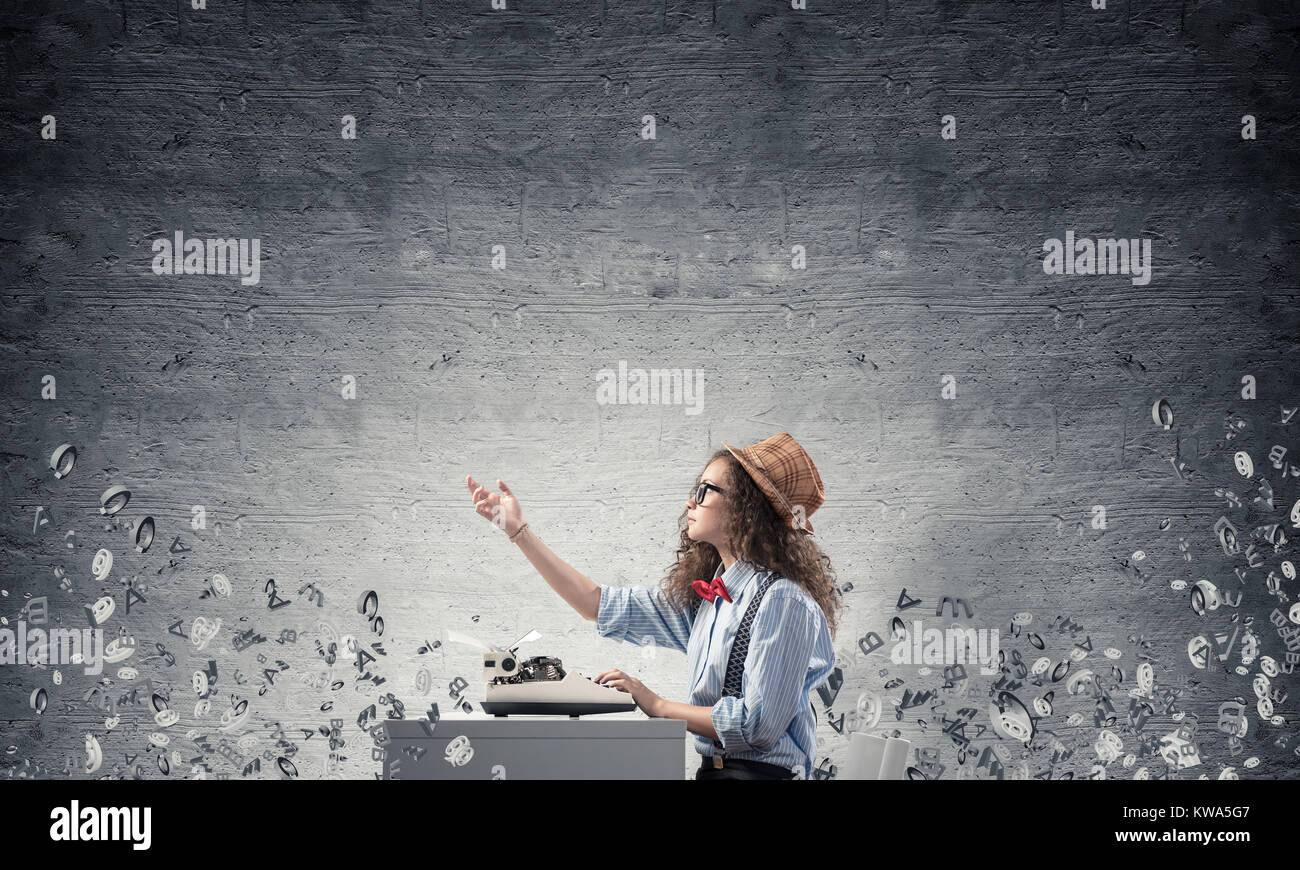 Young and beautiful woman writer in hat and eyeglasses using typing ...