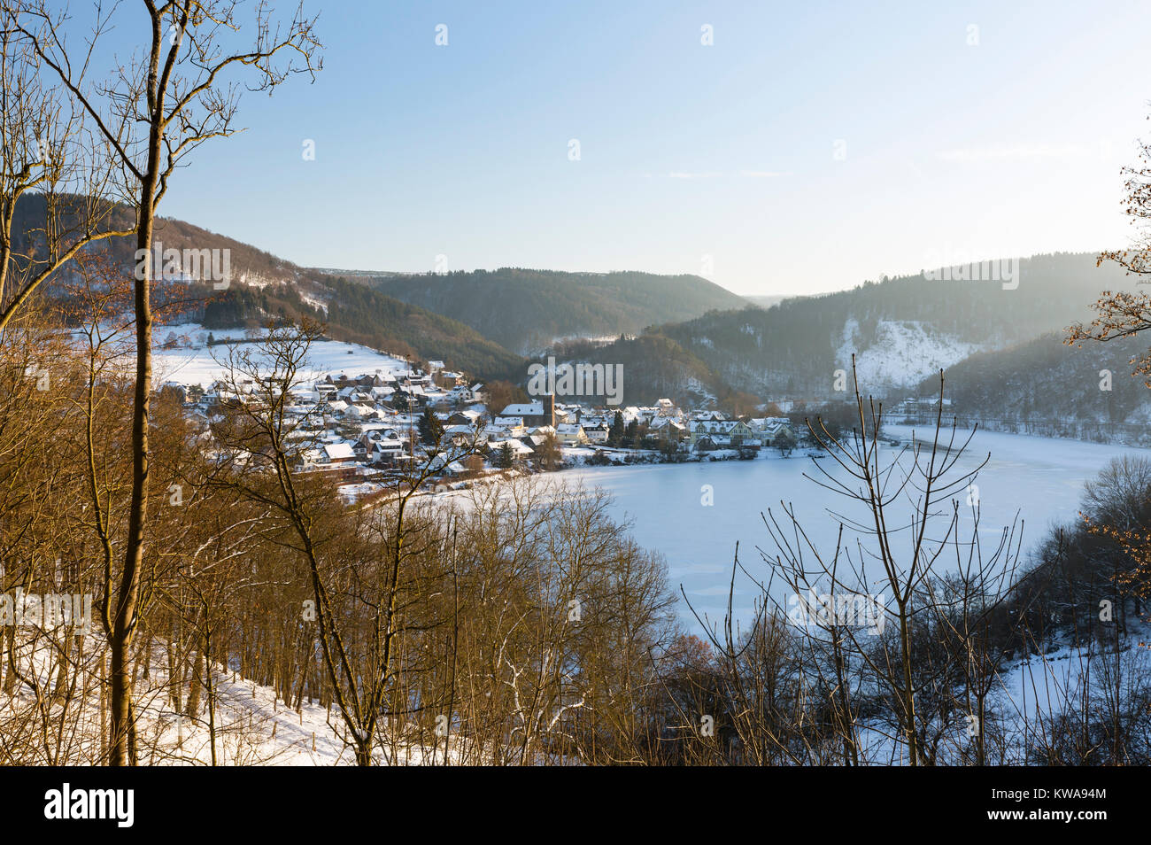 View over lake Rursee to the village of Einruhr with snow in winter in ...