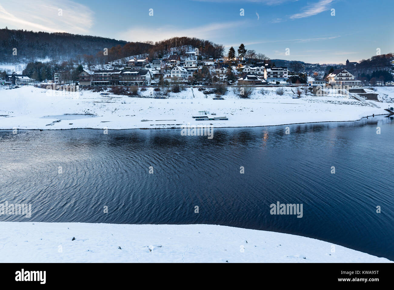 Evening view over lake Rursee to the village of Rurberg with snow in ...