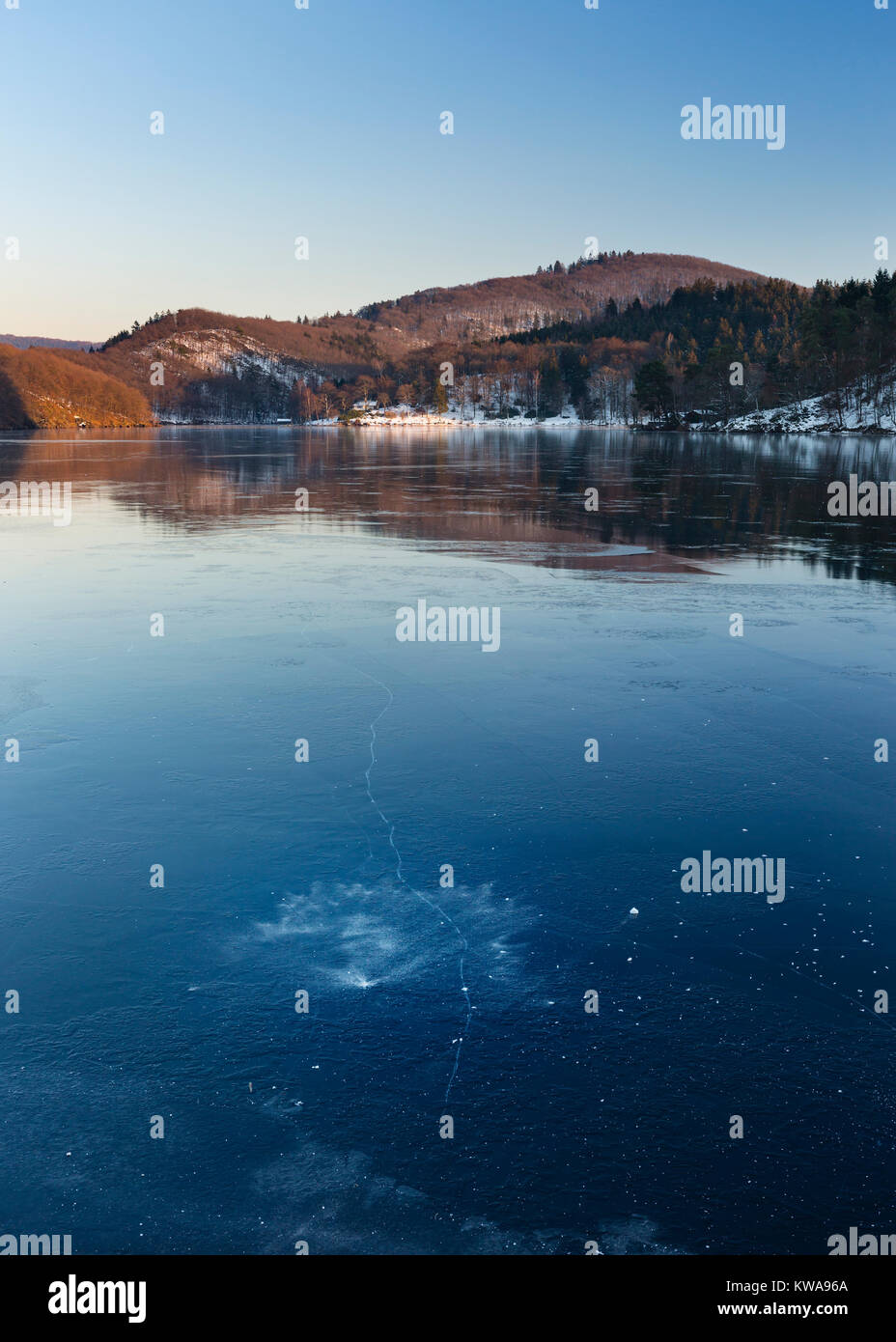 Evening view over the frozen Obersee of lake Rursee near the village of ...