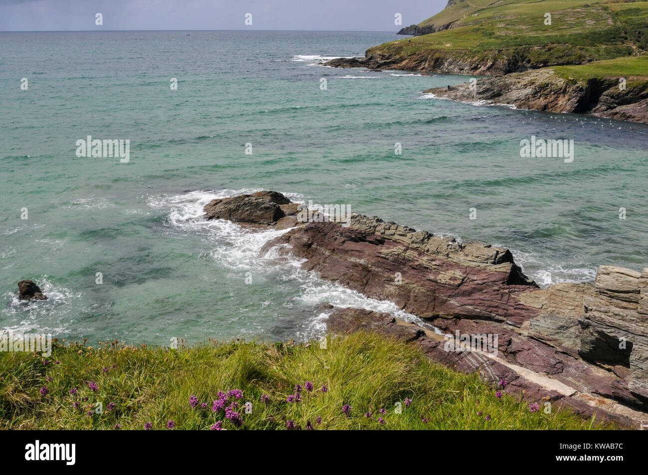 The rocky Cornish coastline from a clifftop on a sunny summer day with ...