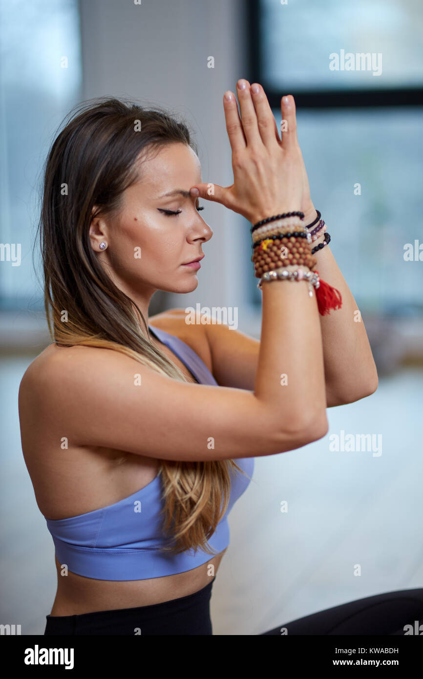 Young woman yoga practitioner or trainer indoor in various poses ...