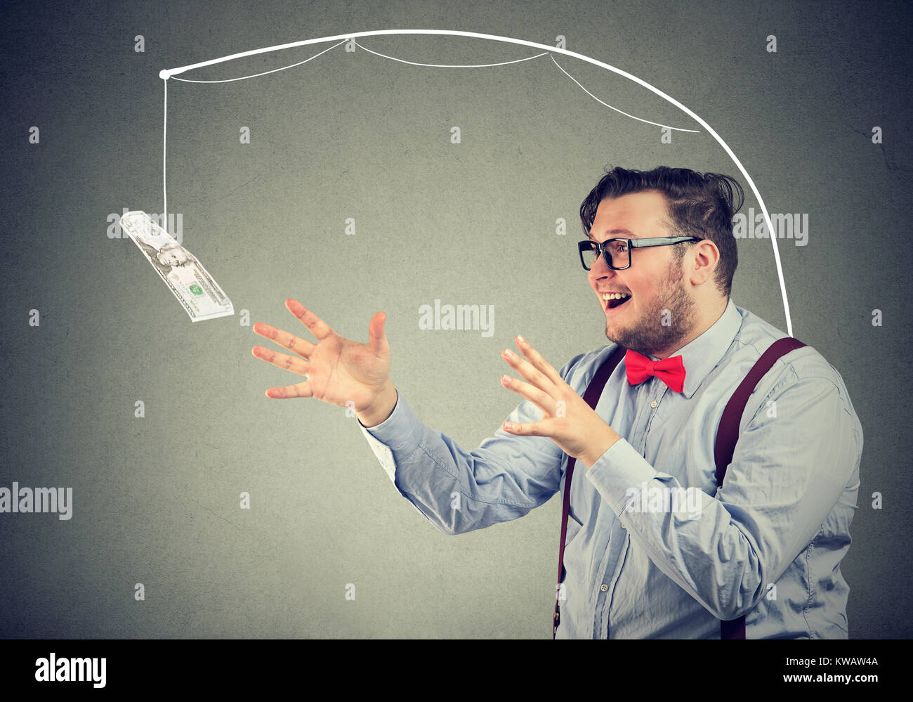 Greedy man chasing dollar bill on gray background Stock Photo - Alamy