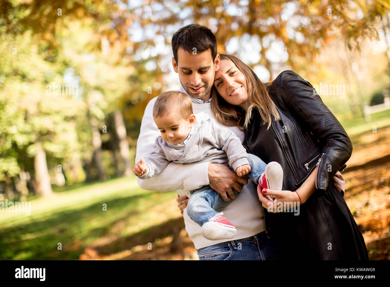 Happy young parents have fun with baby boy in autumn park Stock Photo ...
