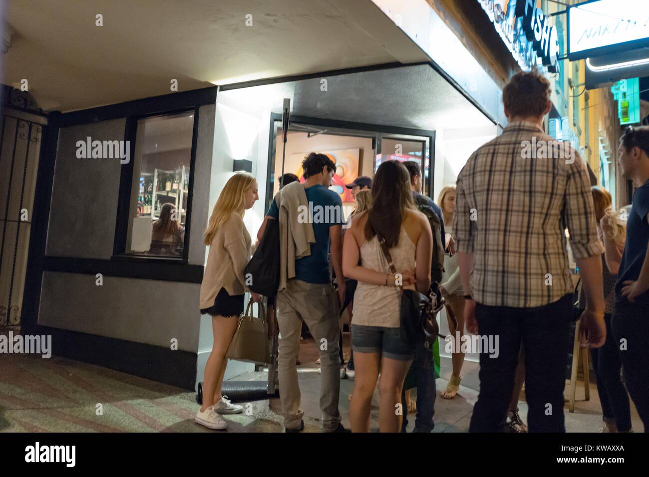 A small crowd of people wait outside of the entrance of a business, San ...