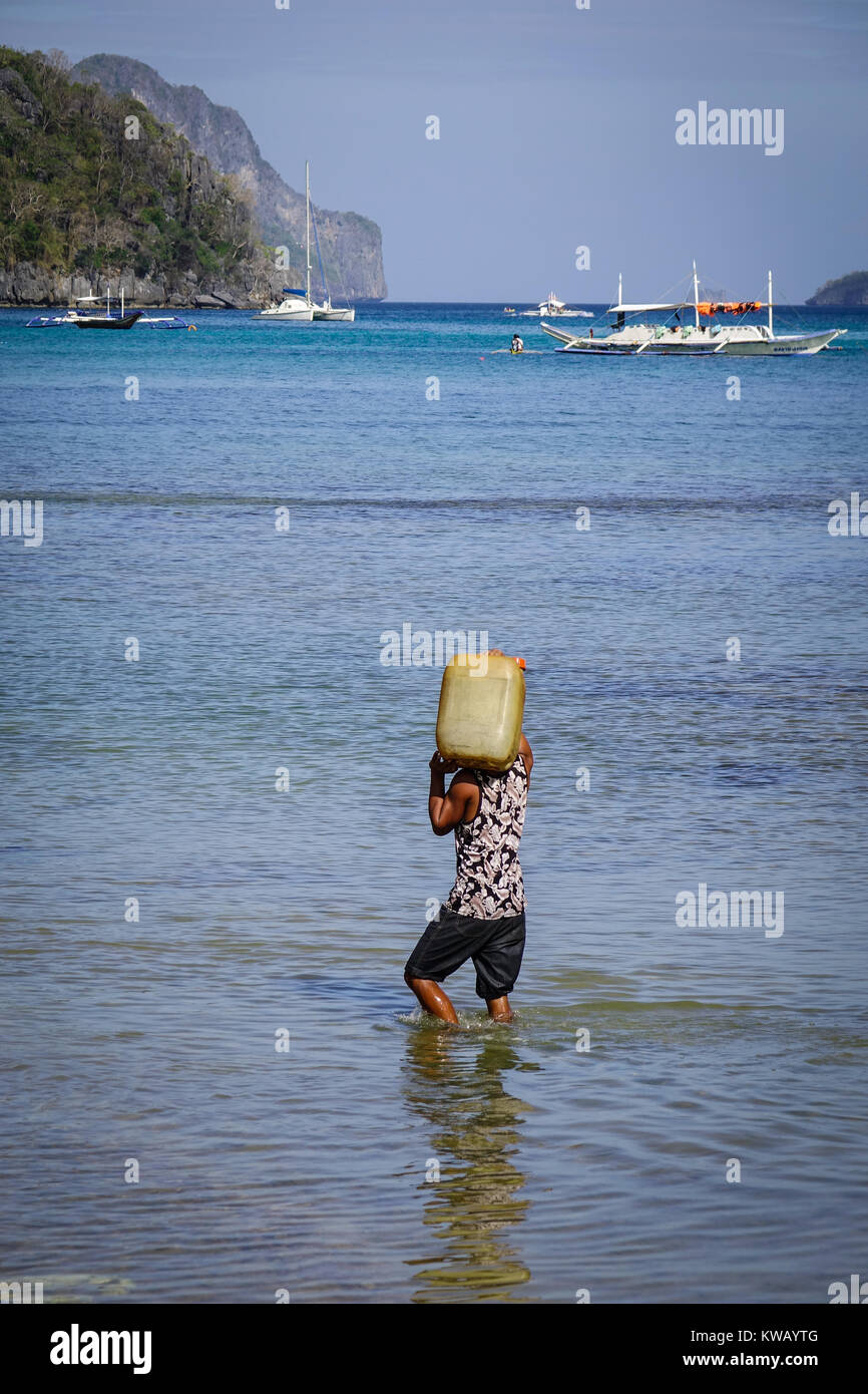 A man carrying water on the beach at sunny day in summer Stock Photo ...