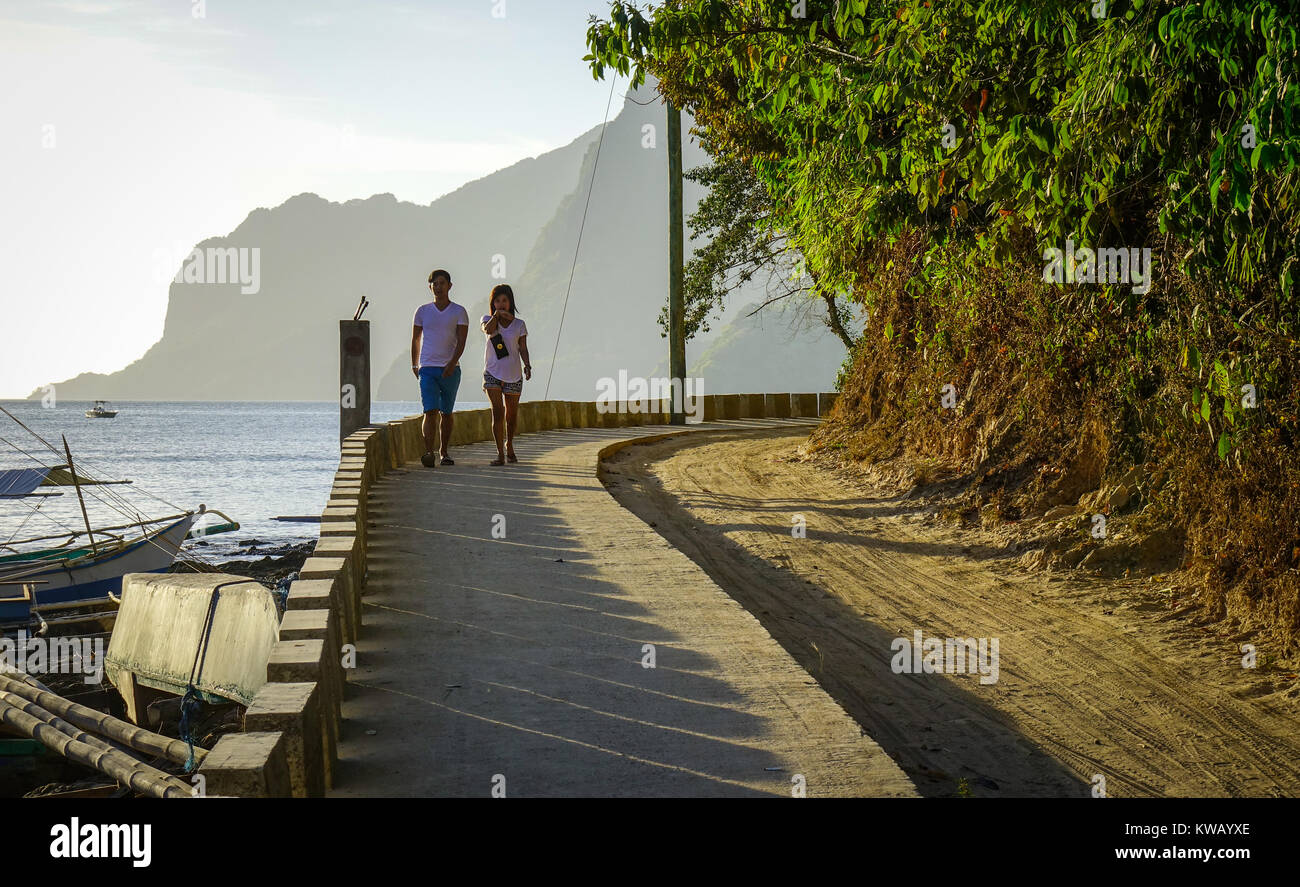 Palawan, Philippines - Apr 5, 2017. A couple walking on rural road at ...