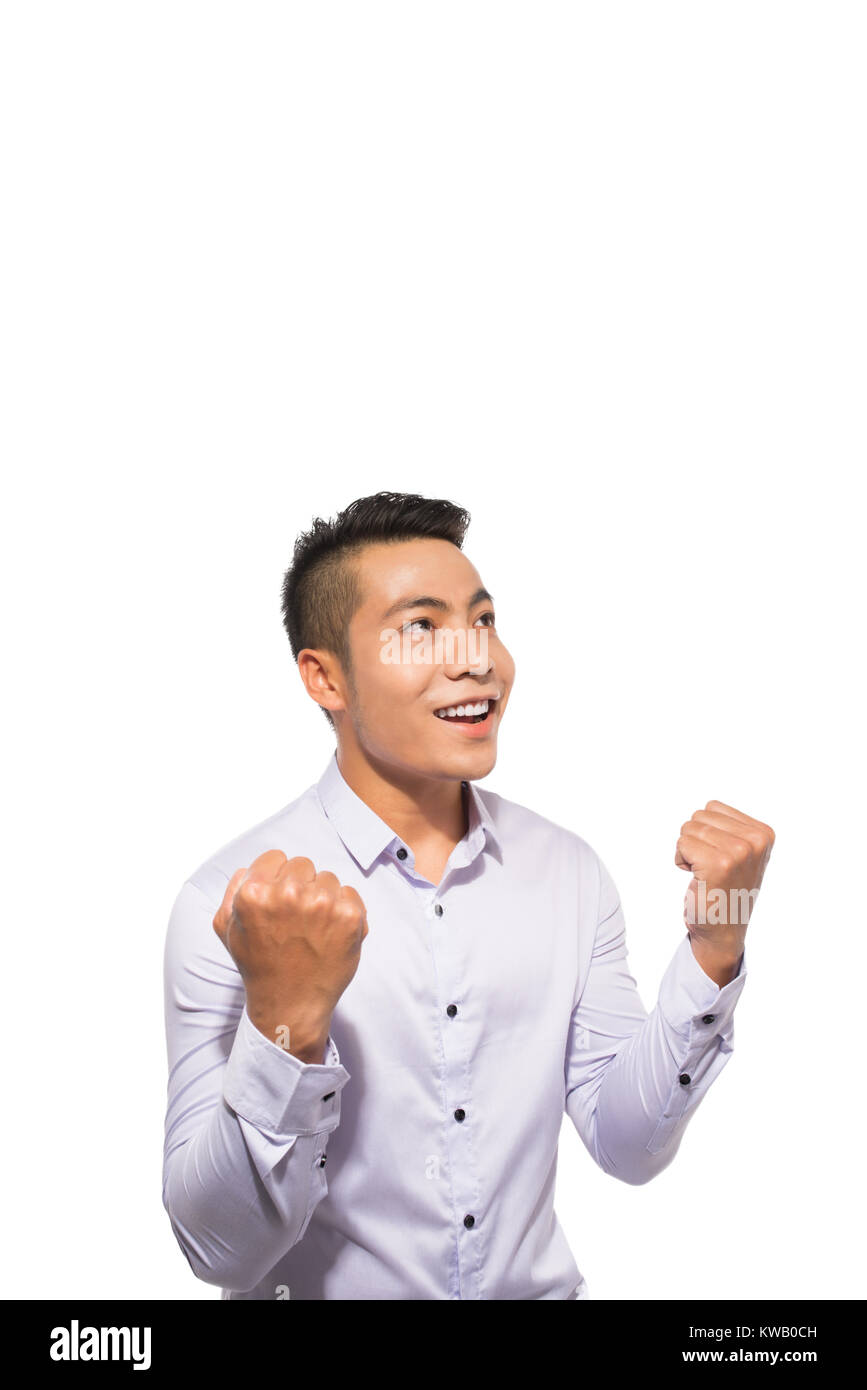Portrait of an asian excited casual man standing with raised hands ...