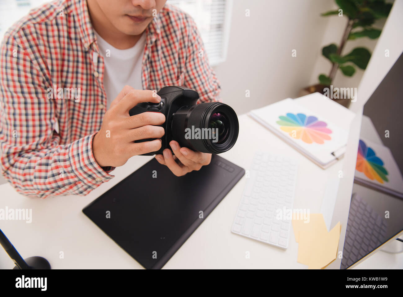 Photographer working at desk in modern office Stock Photo - Alamy