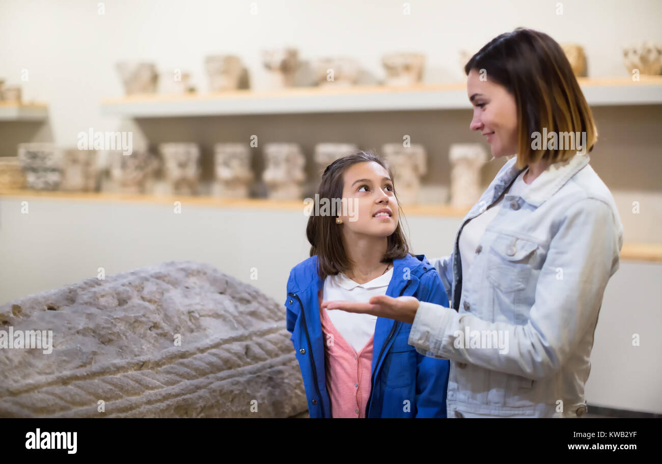 Young mother and daughter exploring a old bas-reliefs in museum. Focus ...
