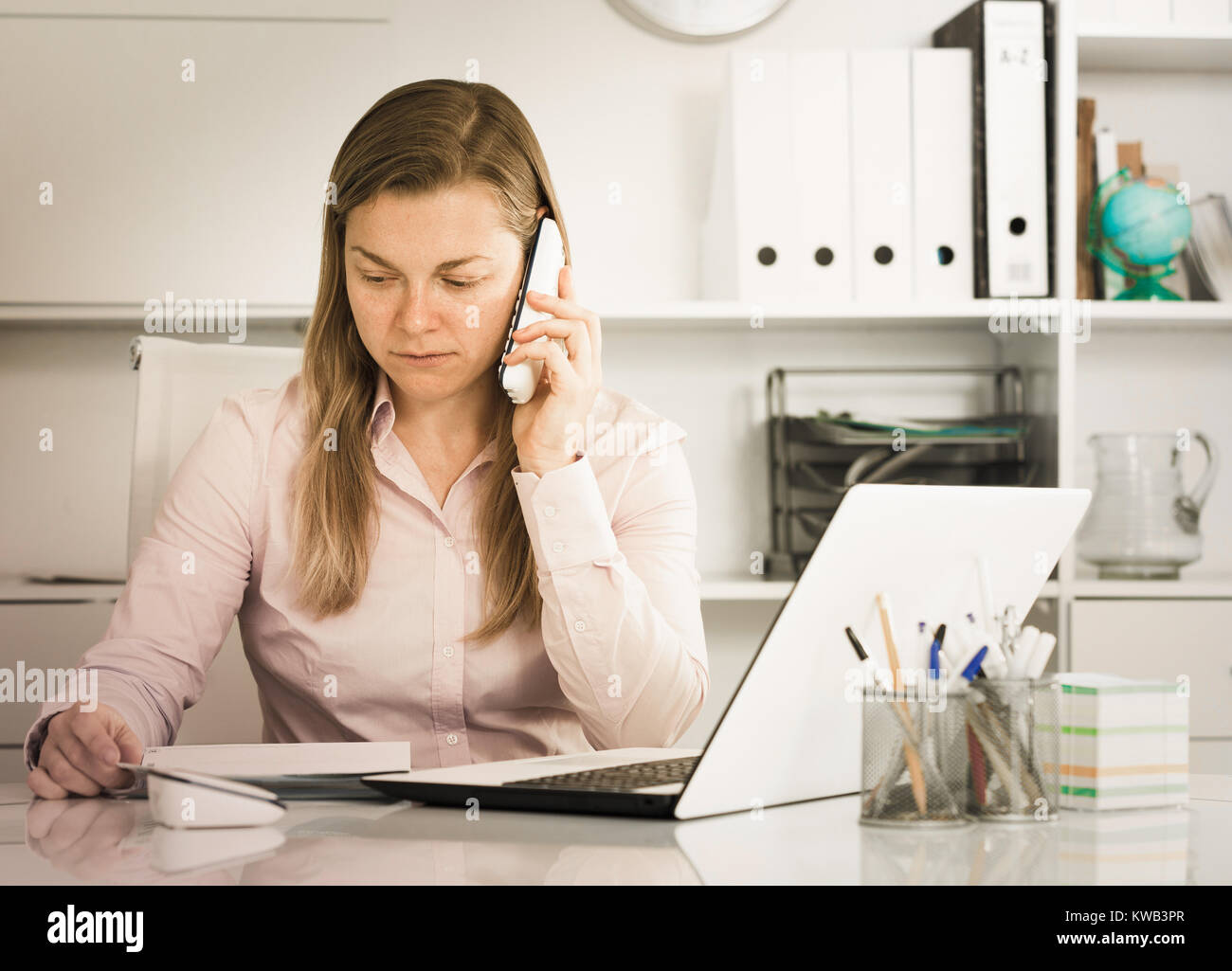 Female employee having conversation on phone during work Stock Photo ...
