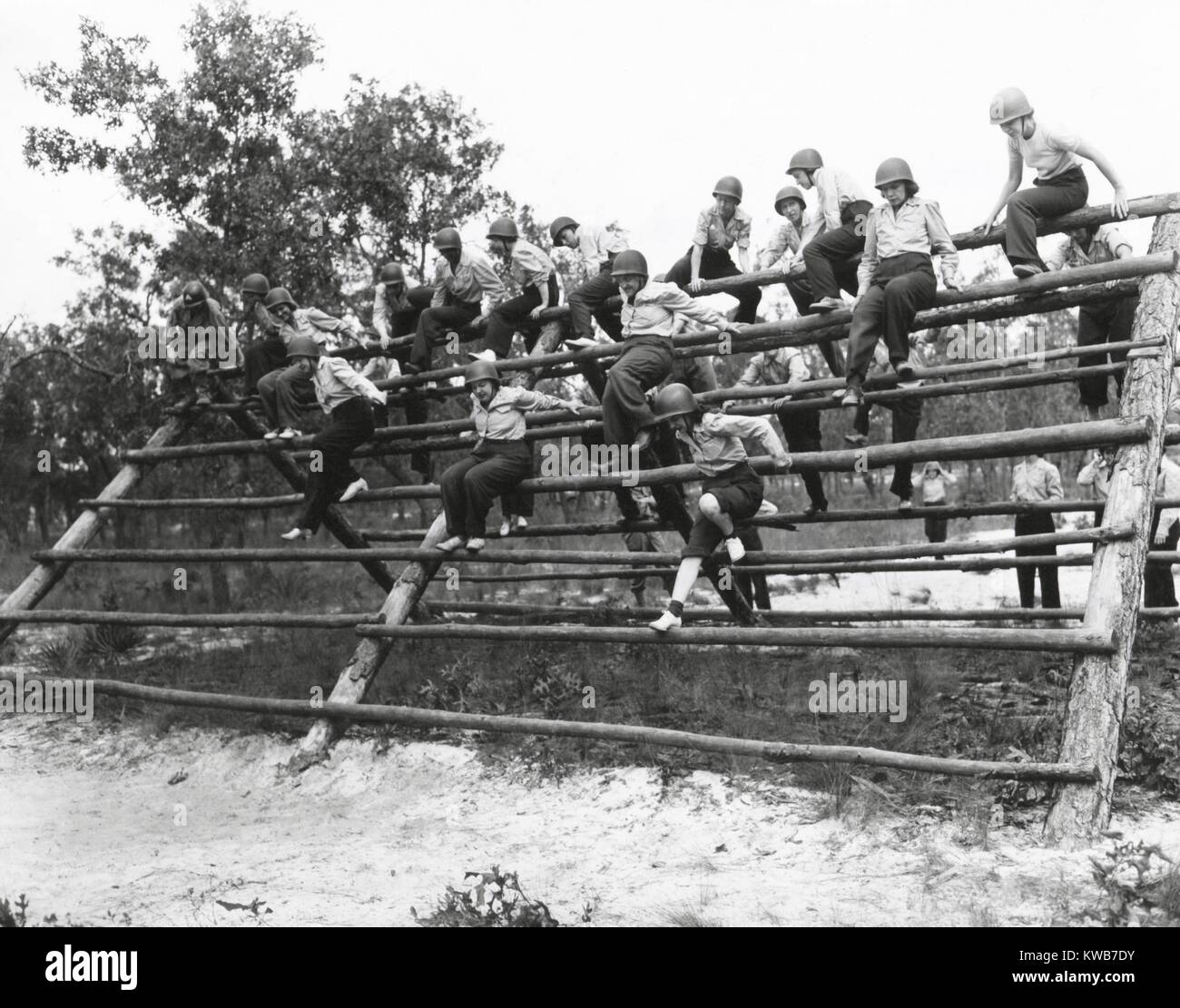 U.S. Women's Army Corps nurses in basic training. The WACs climb a log ...