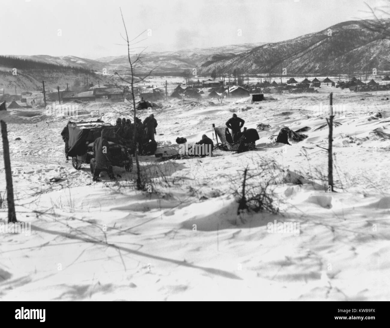 Marines seek shelter from the cold in and around vehicles at a post in ...
