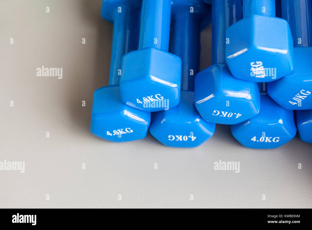Athletic blue dumbbells folded on the gray floor. Studio shot Stock ...