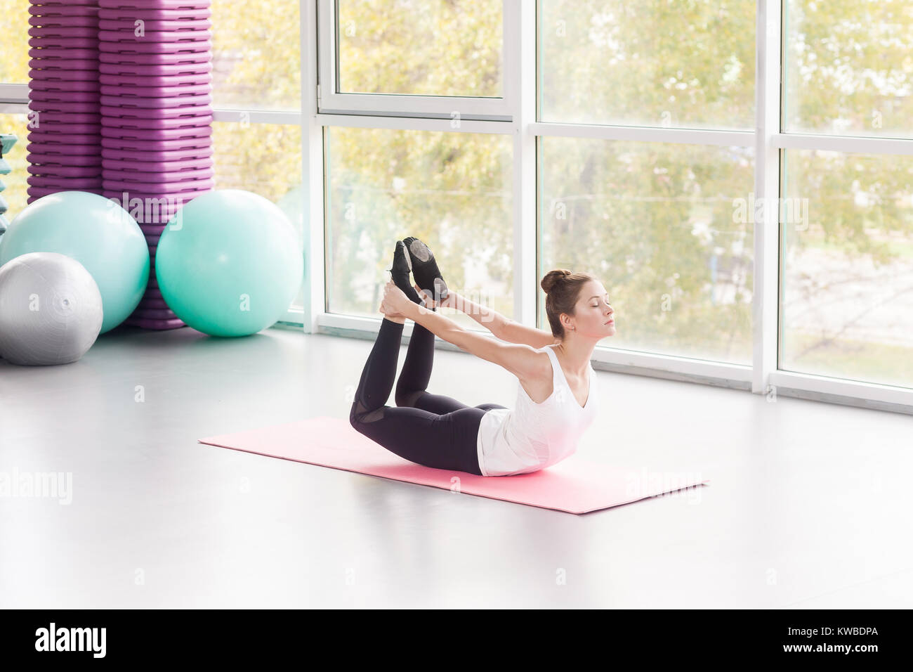 Woman doing yoga, bow posture, yoga. Dhanurāsana. Studio shot Stock ...