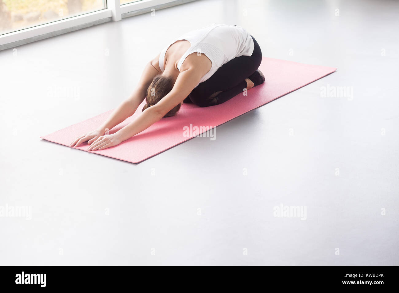 Young woman doing child’s posture. Studio shot Stock Photo - Alamy