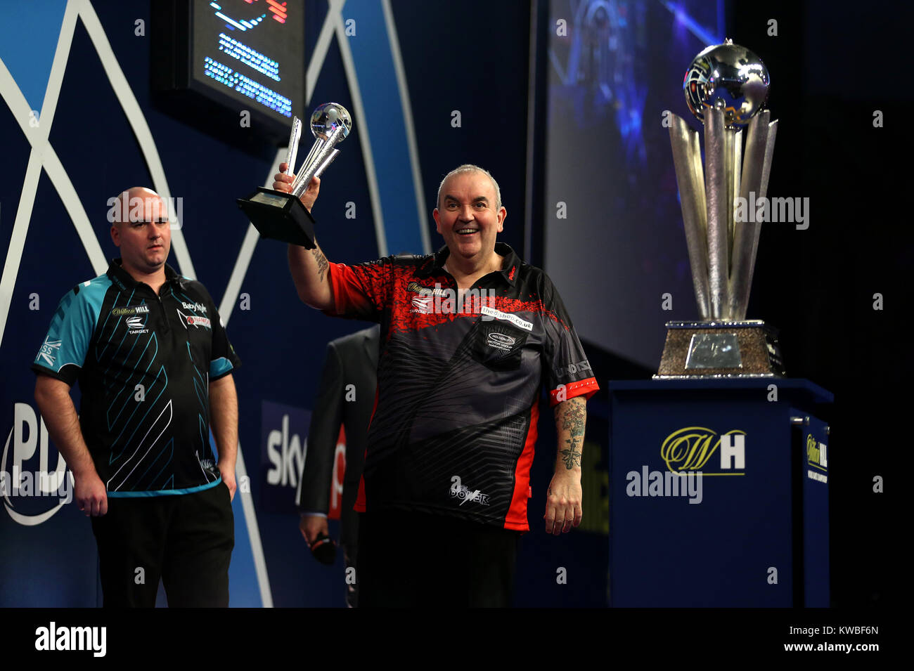 Phil Taylor with his runner's up trophy after loosing to Rob Cross ...
