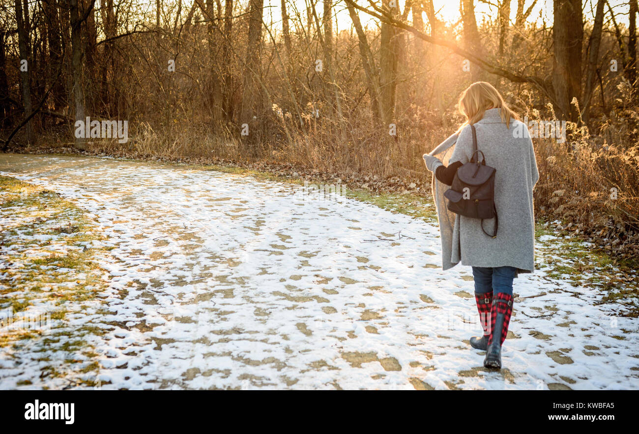 woman walking on wooded path at sunset in winter Stock Photo - Alamy