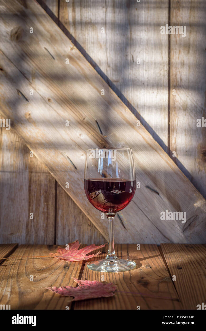 glass of red wine on rustic wood table and barn door Stock Photo - Alamy