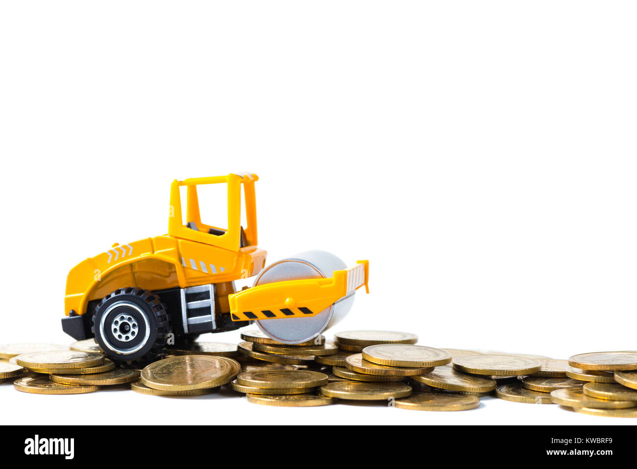Mini Road roller machine with stack coin with pile of gold coin ...
