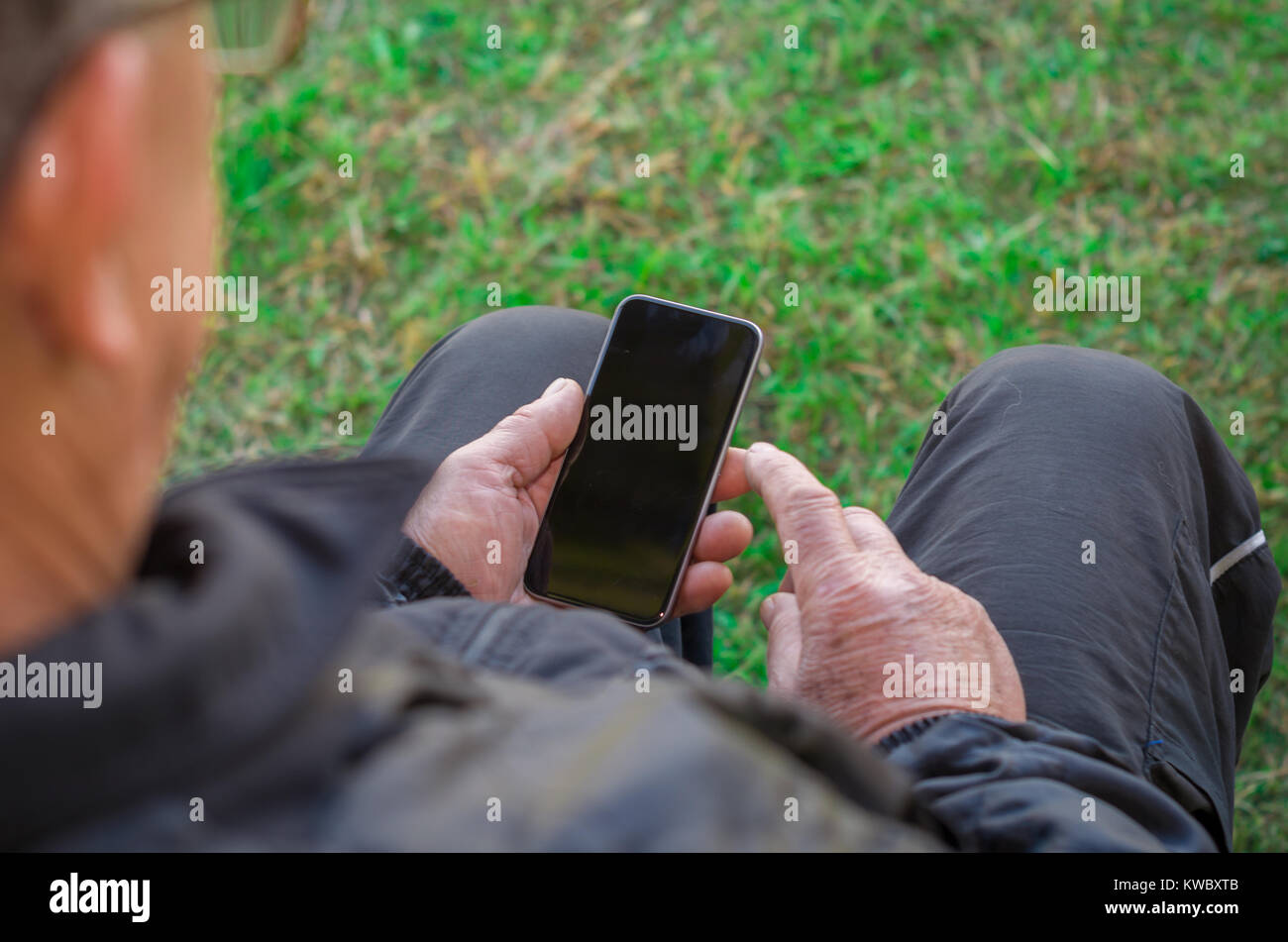 Close up of a wrinkled finger touching a smartphone, old man uses ...