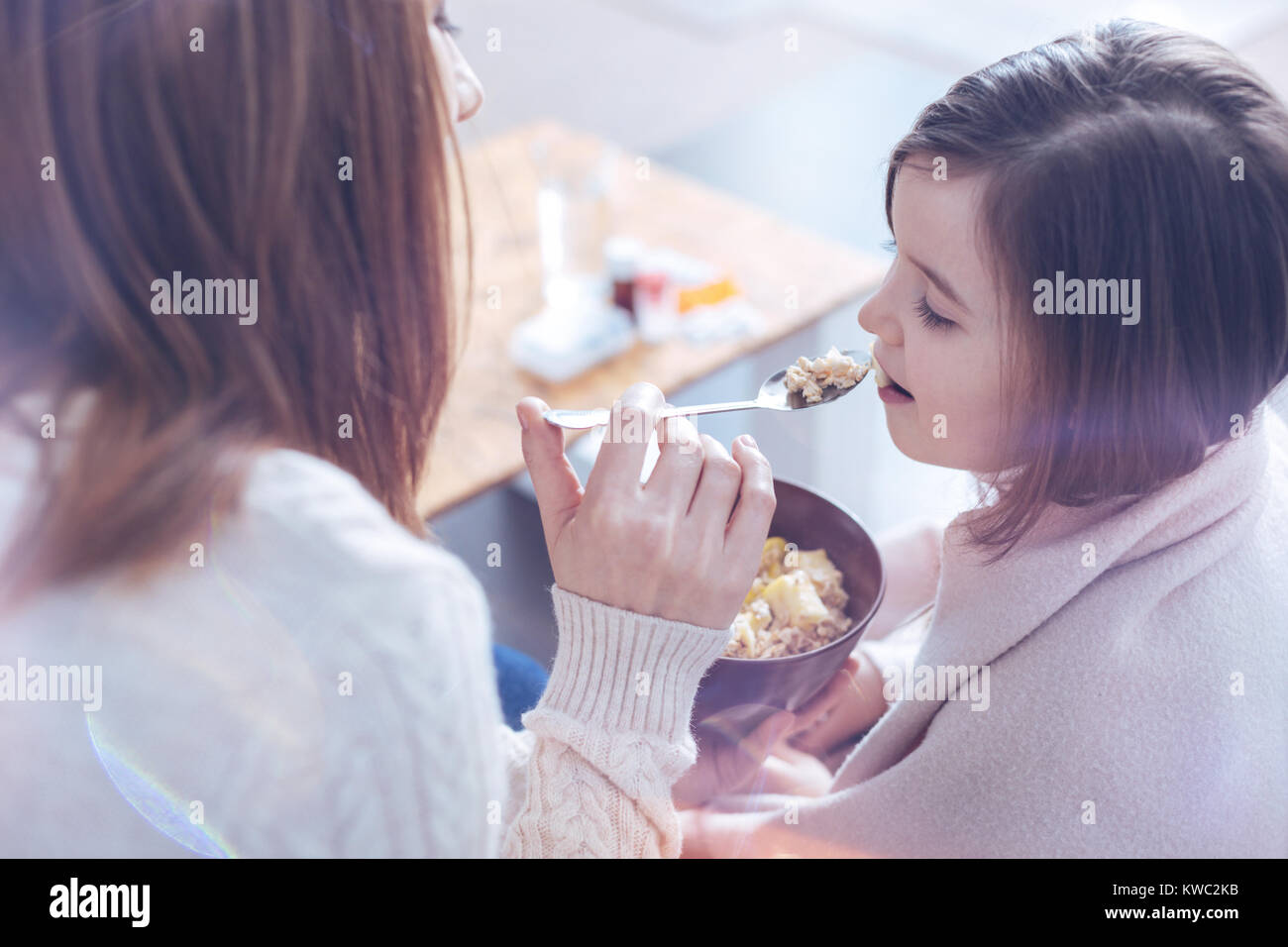 Profile photo of mother that giving dinner to her daughter Stock Photo ...