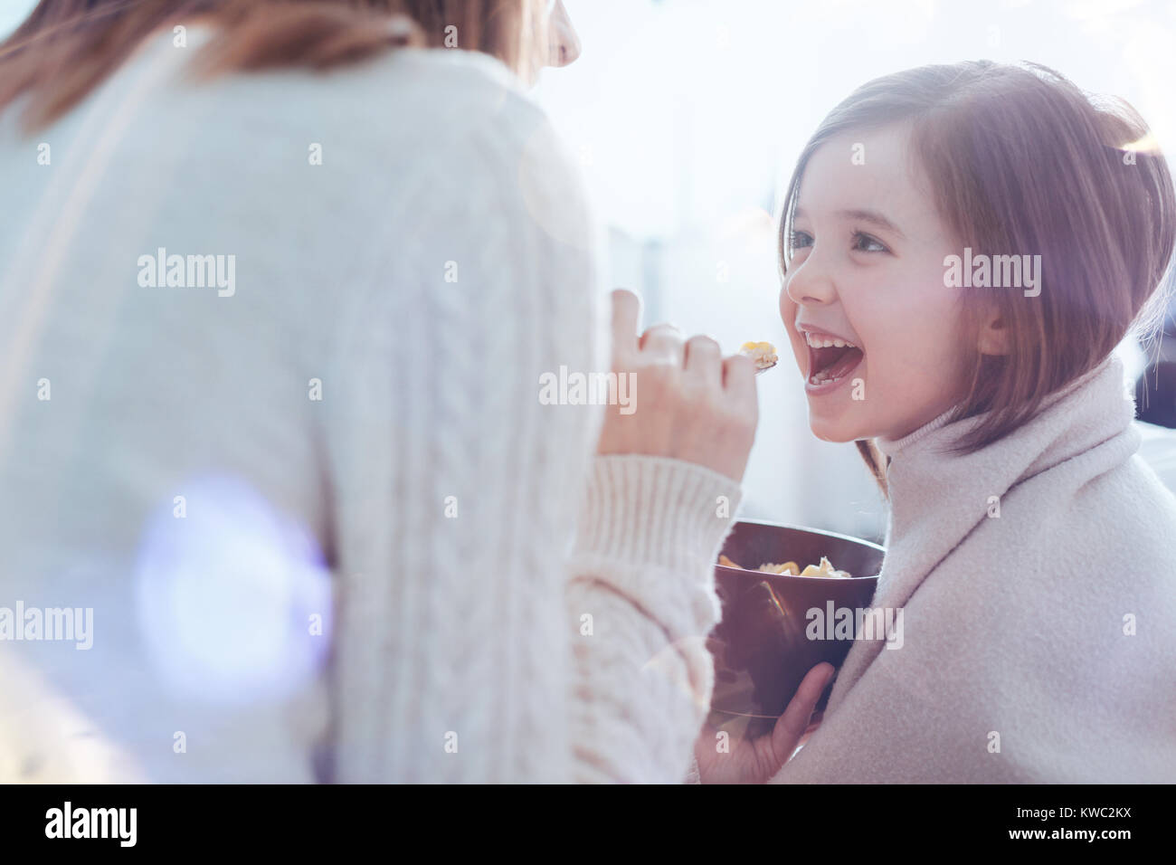 Pretty smiling girl eating her breakfast Stock Photo - Alamy