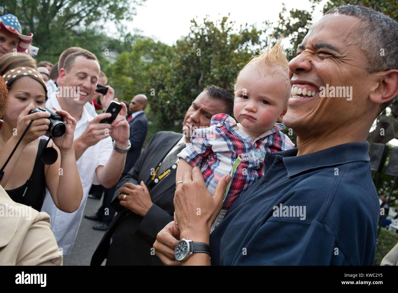 President Barack Obama holds a baby during an White House Independence ...