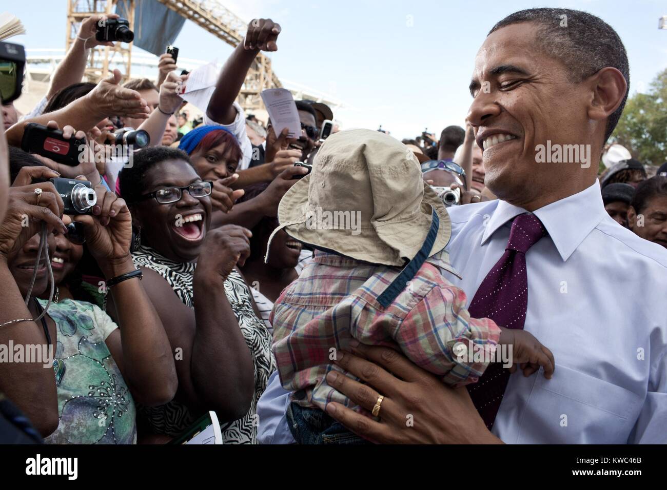 President Barack Obama holds a baby after delivering speaking in ...