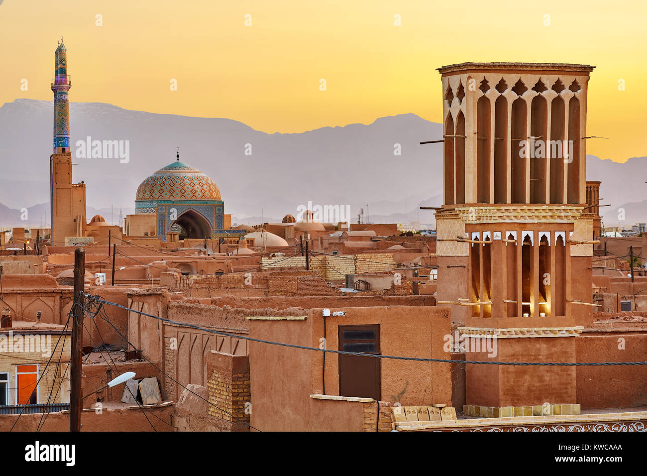 A view of the old town of Yazd with clay buildings, a mosque with ...