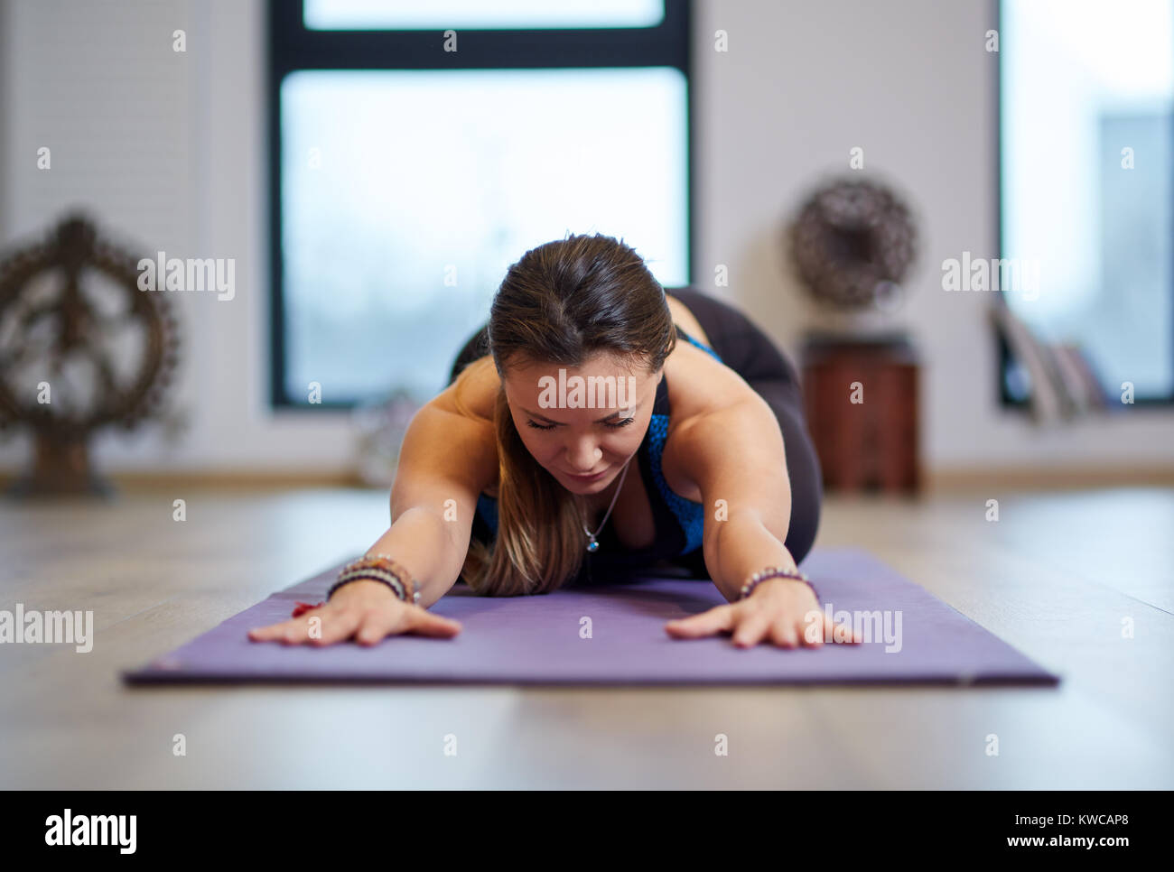 Young woman yoga practitioner or trainer indoor in various poses ...