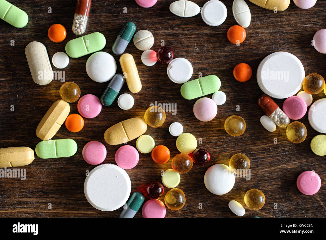 Medical background of various colorful medications on a textured wooden ...
