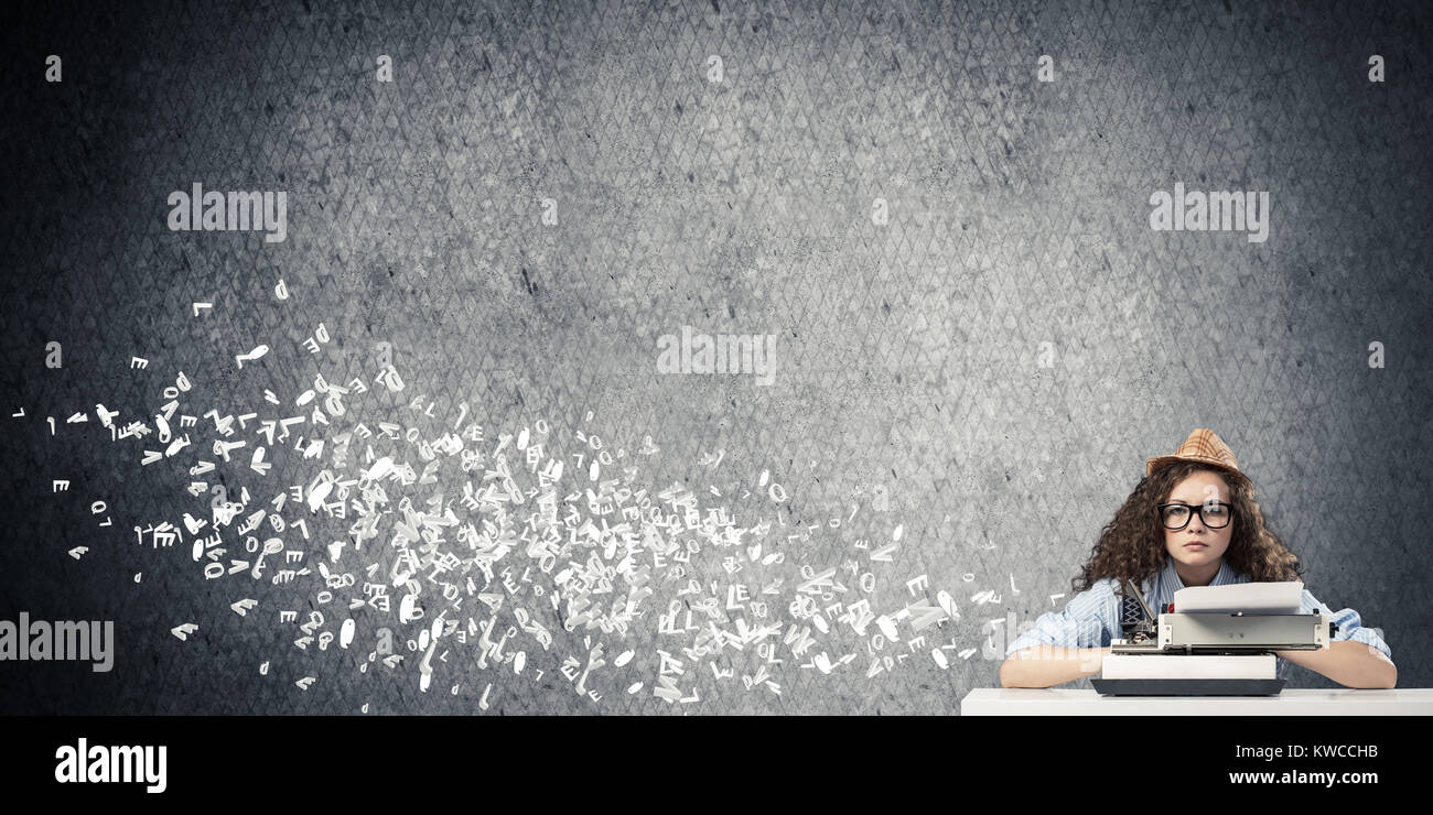 Young and beautiful woman writer in hat and eyeglasses using typing ...