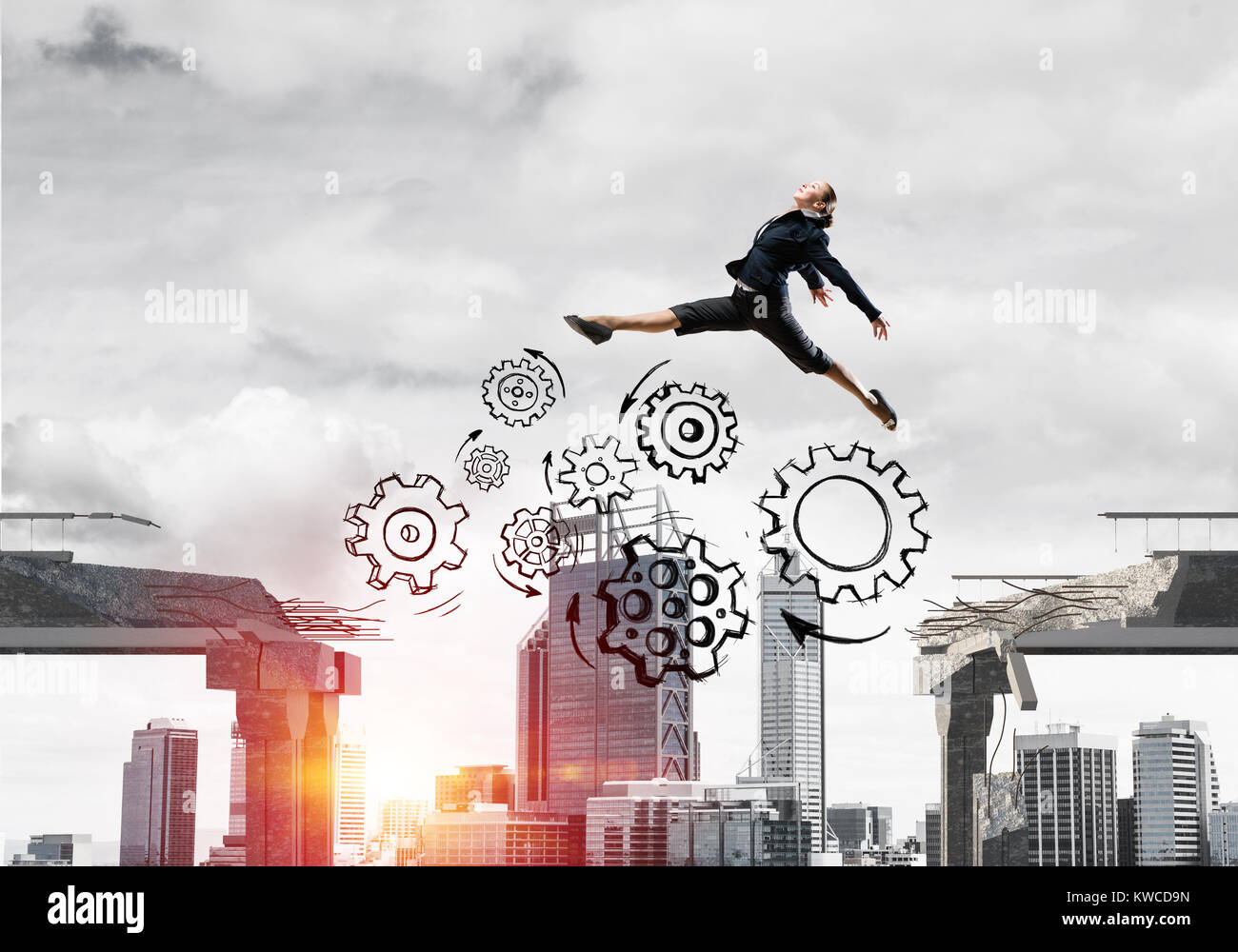 Business woman jumping over gap with gear mechanism in concrete bridge ...