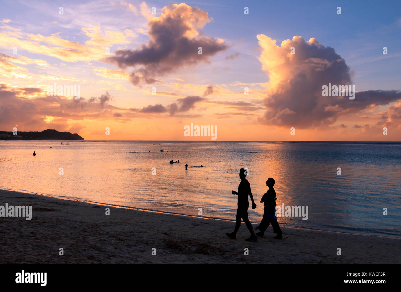 Silhouette of couple walking on Tumon Beach, Tamuning, Guam Stock Photo ...