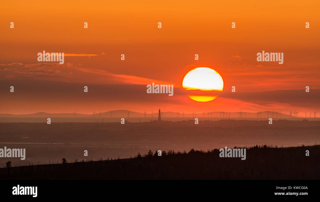 Sunset over the Isle of Man with a distant Blackpool in the foreground ...