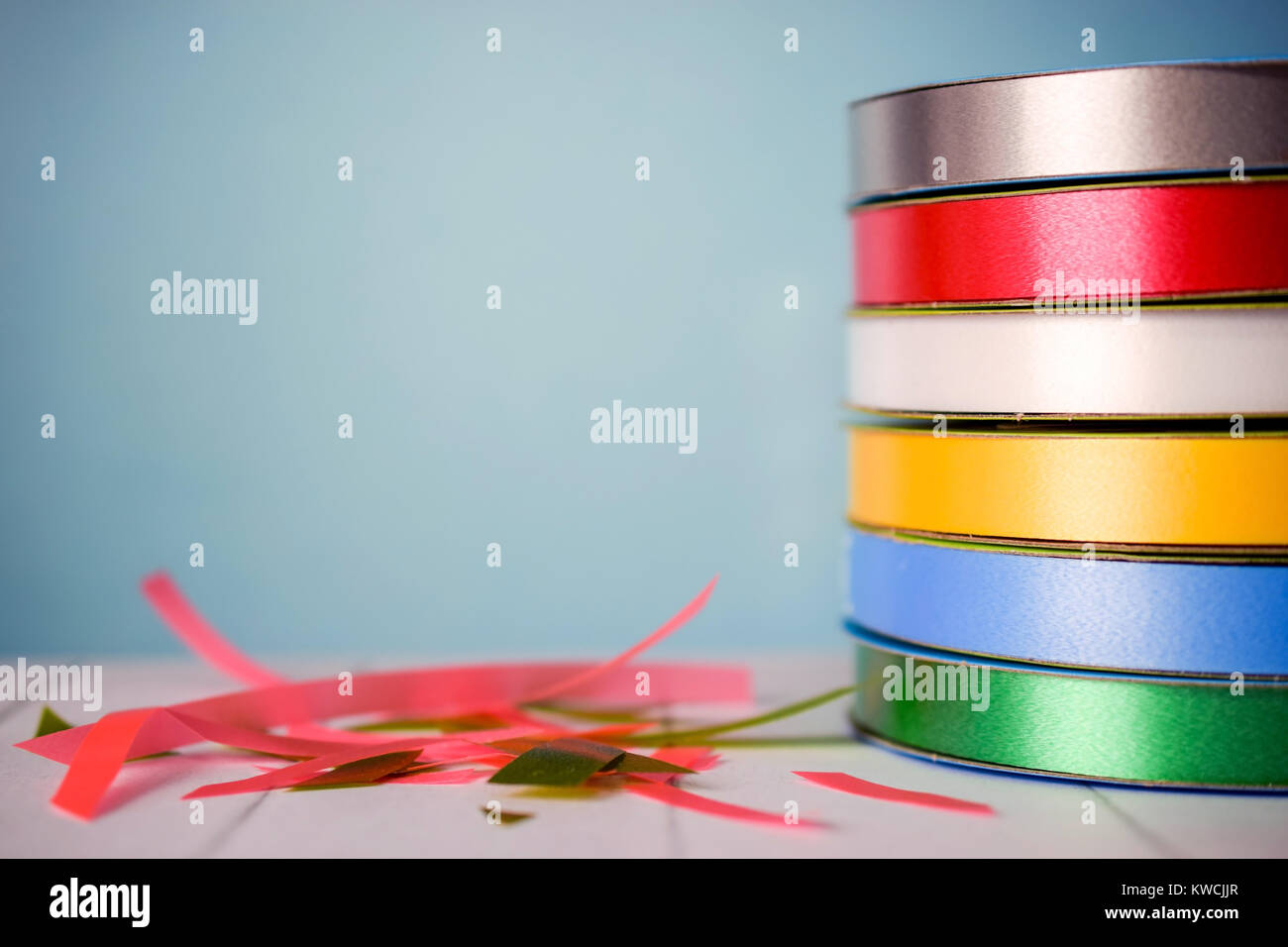 Stack of color ribbons on table with blue background Stock Photo - Alamy