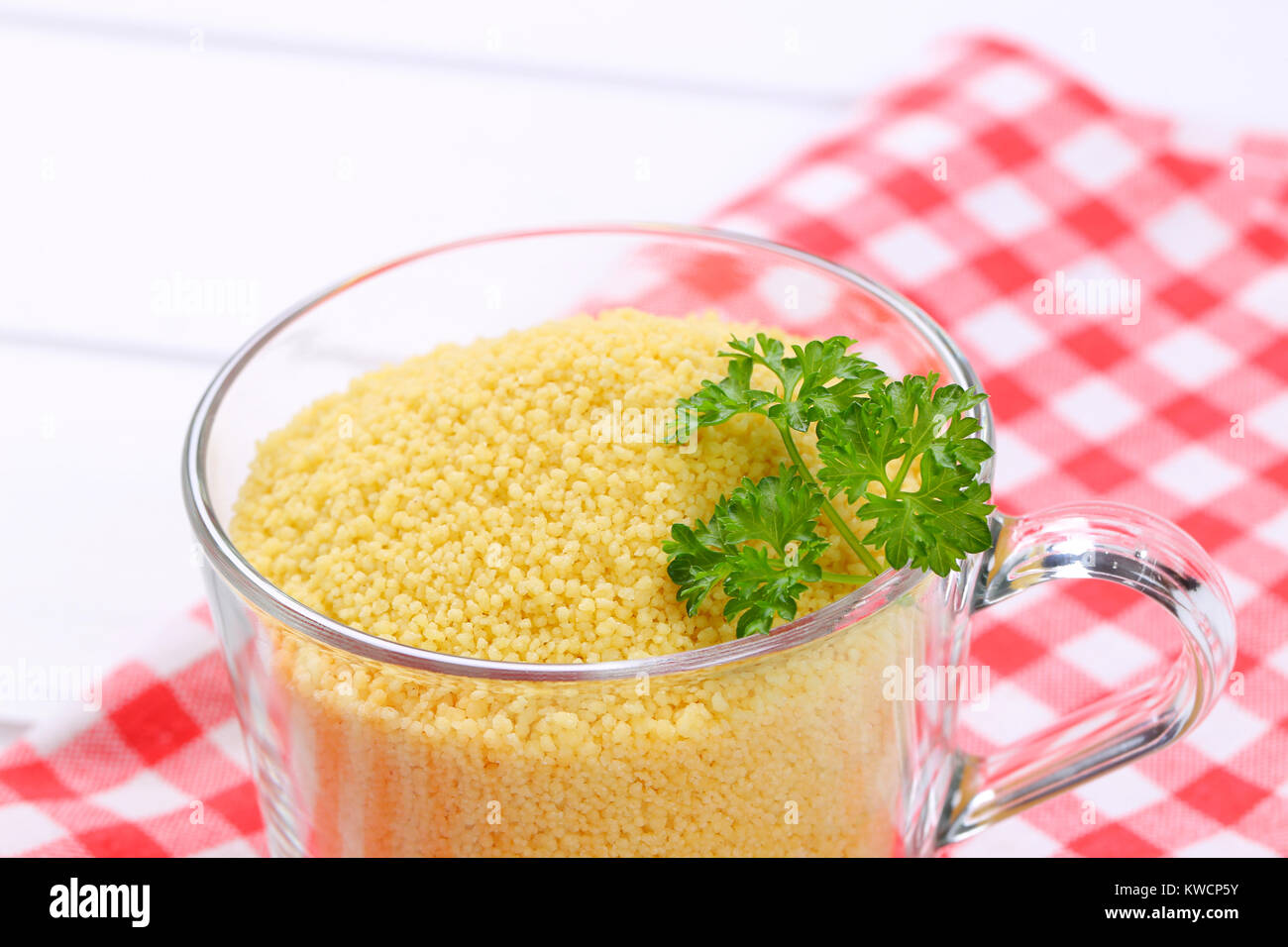 cup of raw couscous on checkered place mat - close up Stock Photo - Alamy