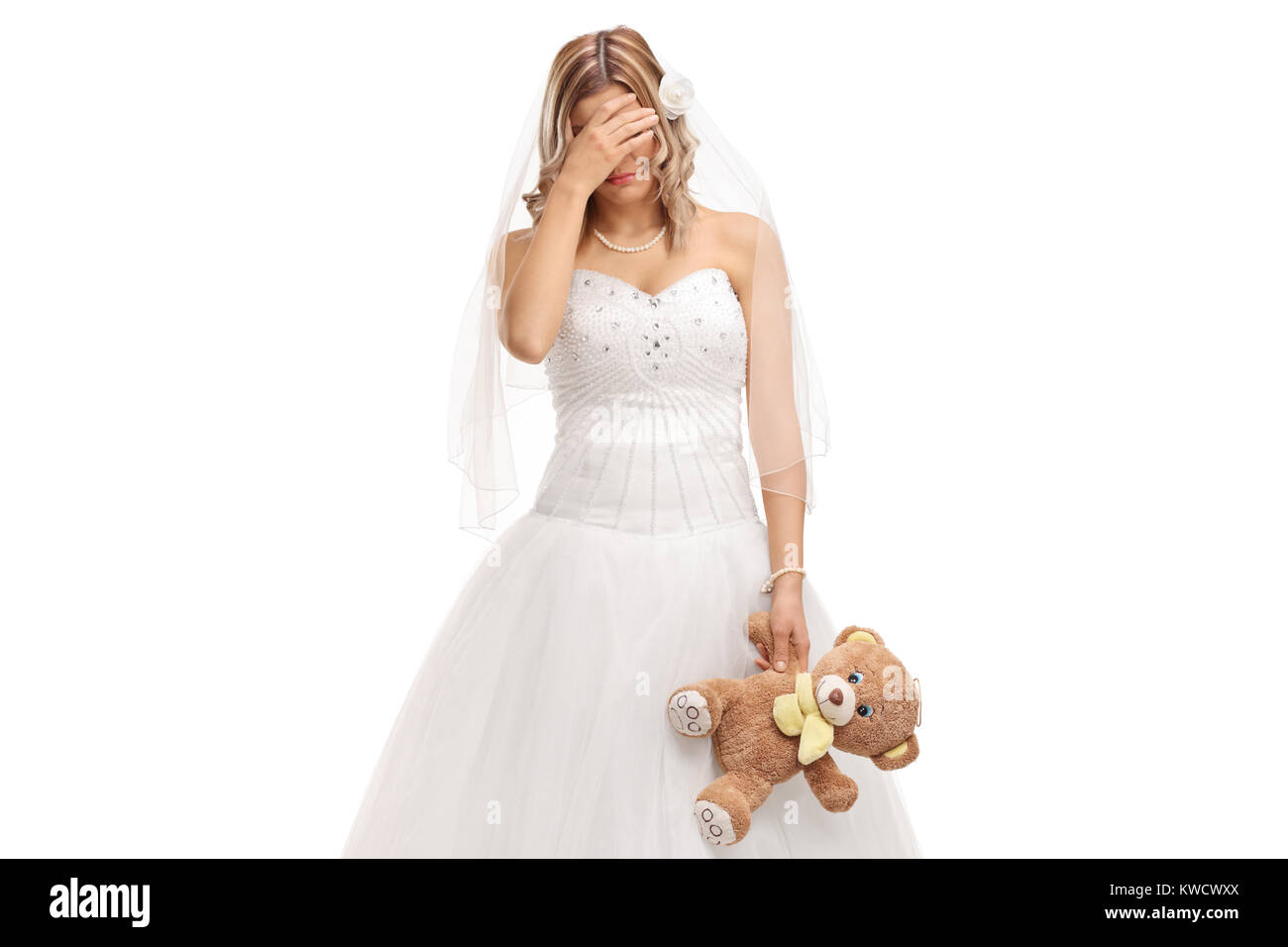 Sad young bride with a teddy bear crying isolated on white background ...