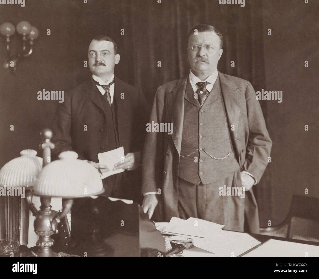 Theodore Roosevelt standing behind desk, with Asst. Presidential ...