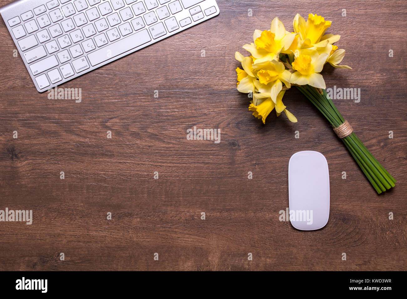Office workplace with keyboard, a computer mouse and a bouquet of ...