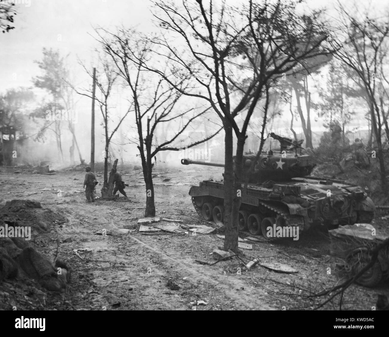 U.S. Marines, supported by one of their tanks, mop up heights on Wolmi ...