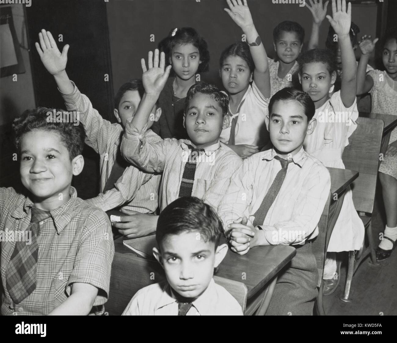 Puerto Rican children in a classroom, some with hands raised. New York ...