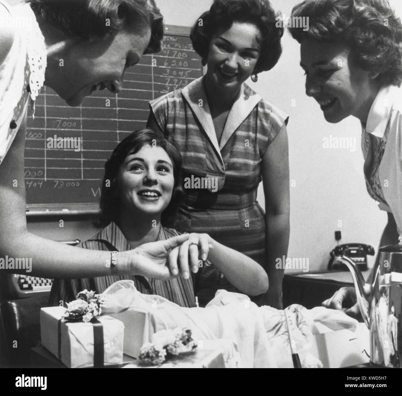 Young working women at an office party for an engaged co-worker. Ca ...
