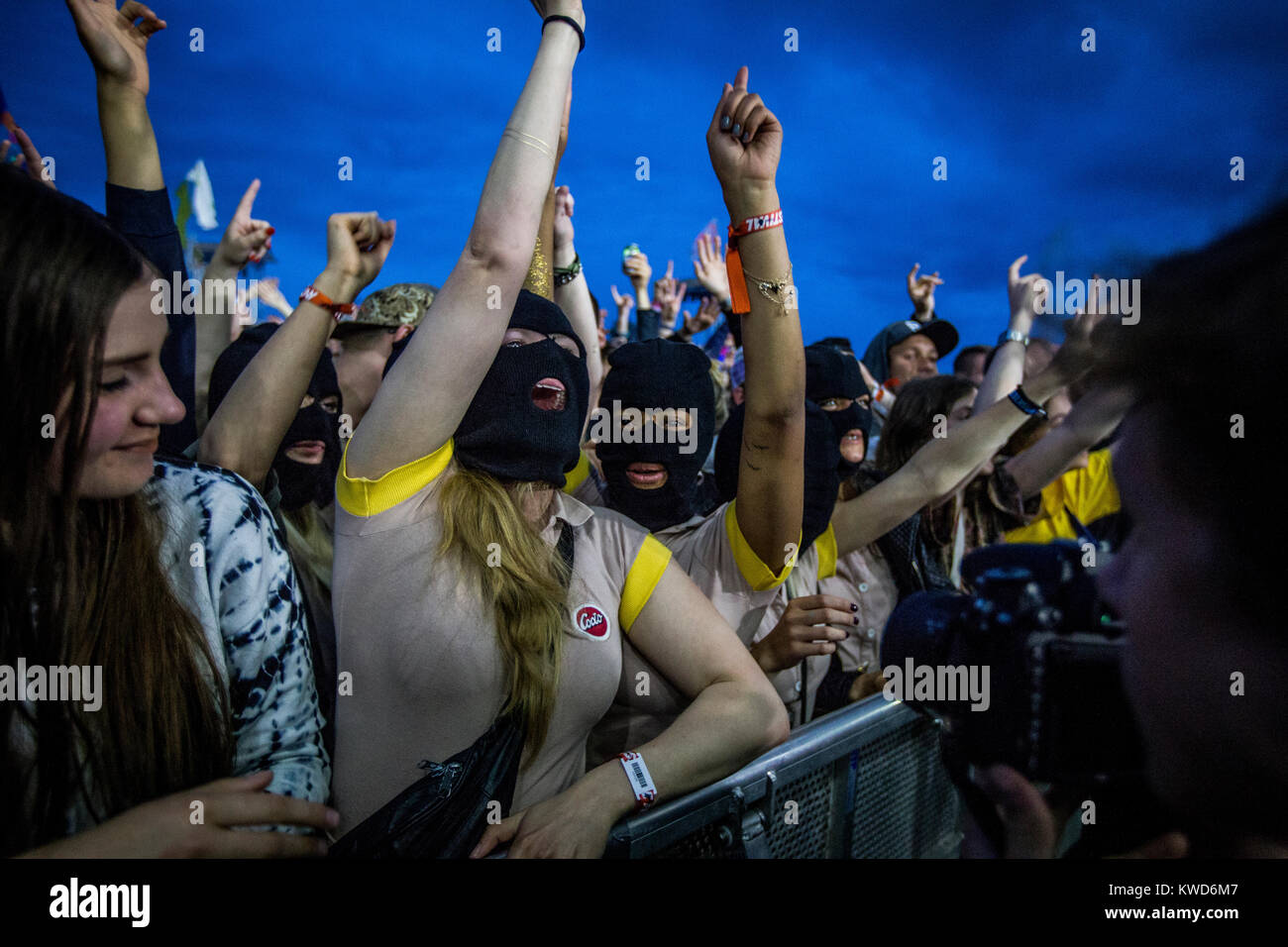 Energetic festival goers and music fans go crazy front row at a live ...