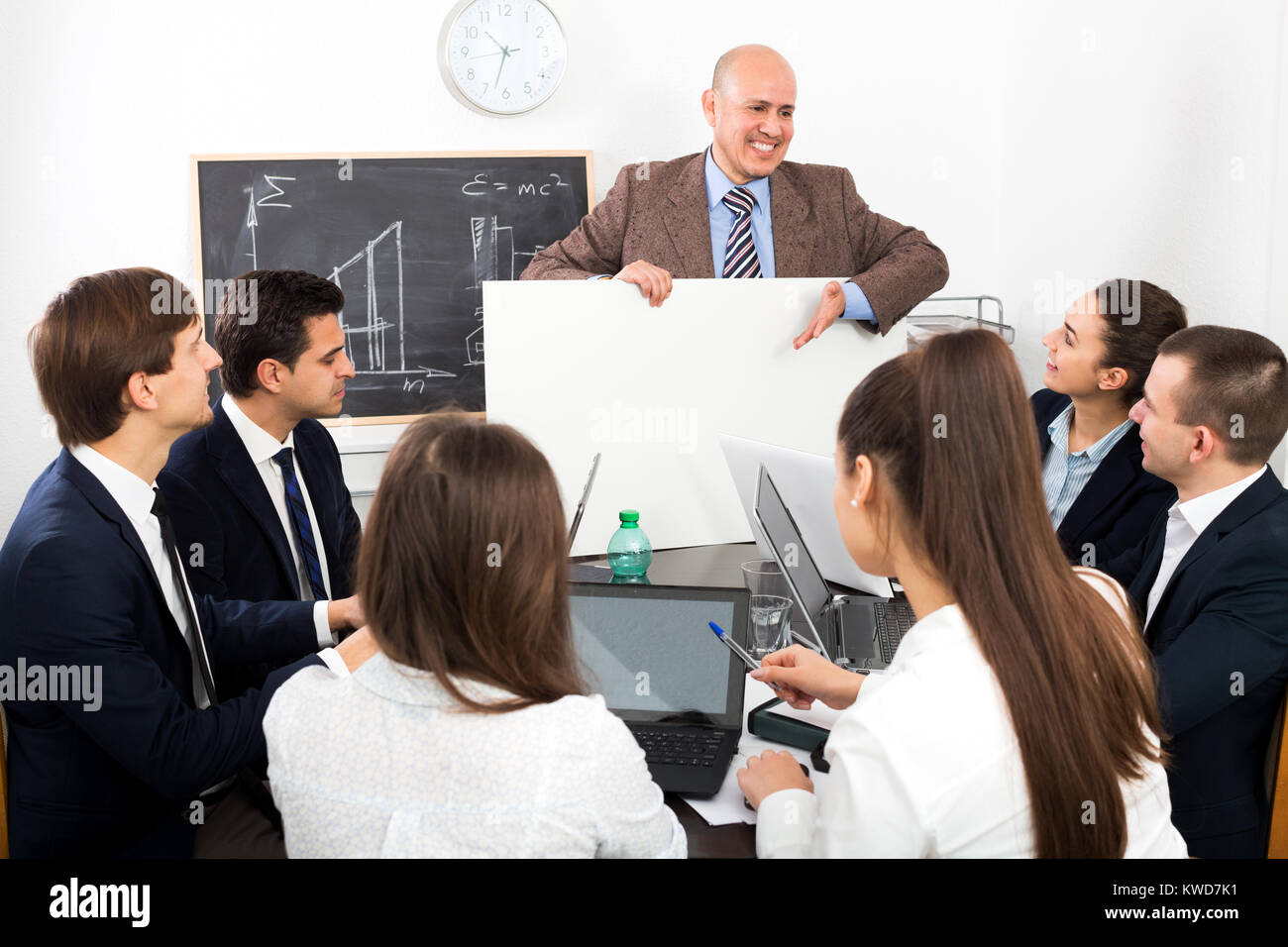 Focused senior businessman presents new development plan at poster ...