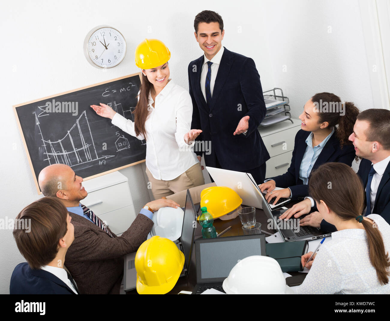 Group of engineers discussing project and smiling indoors Stock Photo ...