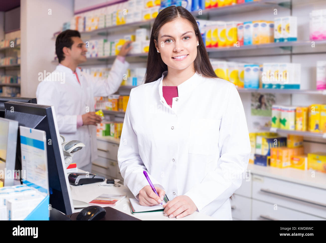 Professional spanish pharmaceutists at reception of drugstore ready to ...