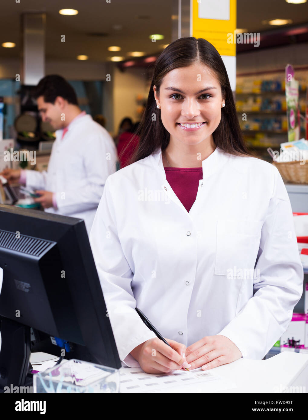 Portrait of smiling pharmacist and assistant working at farmacy ...