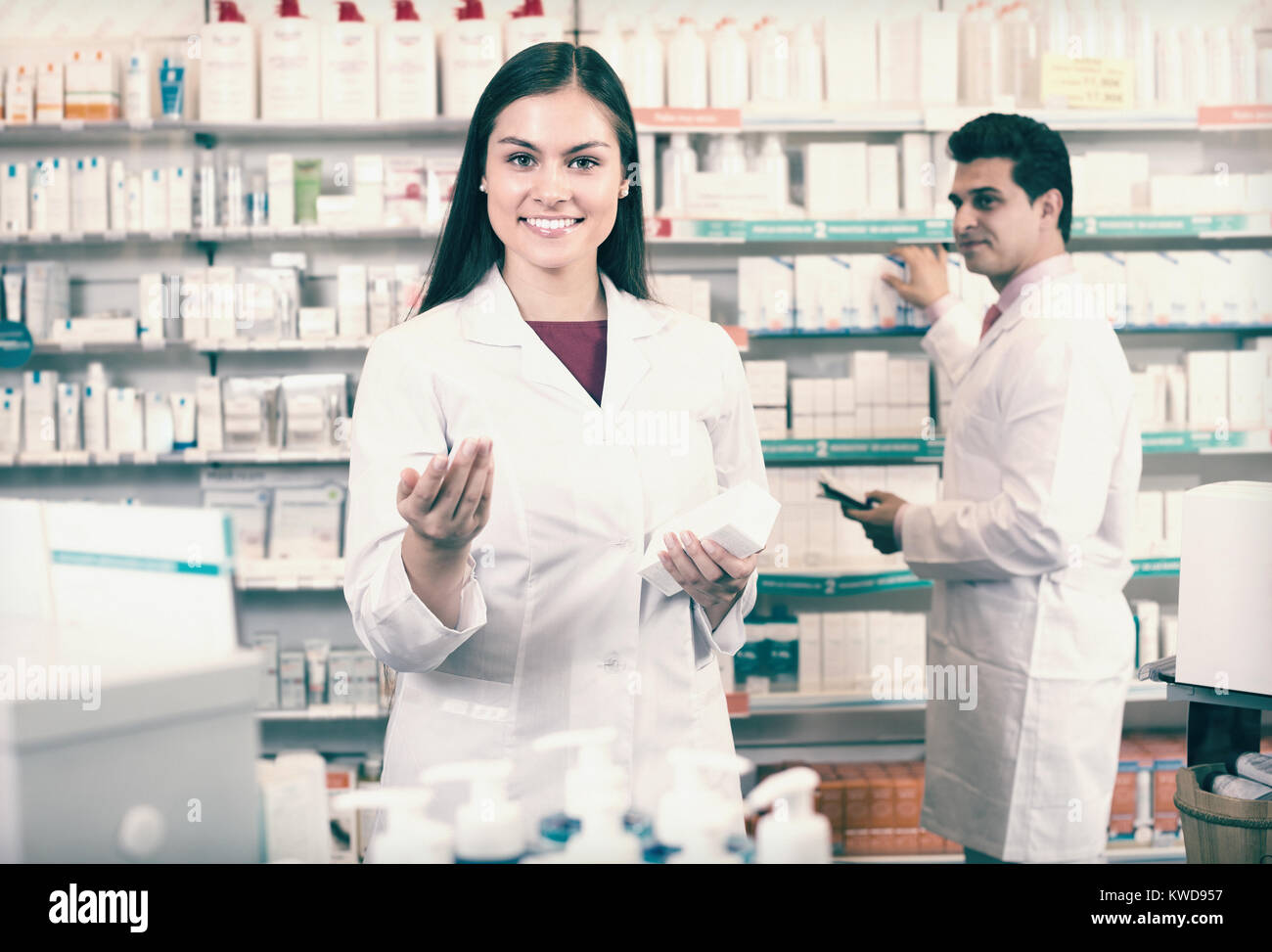 Two positive smiling professional pharmacists in uniform at the work in ...